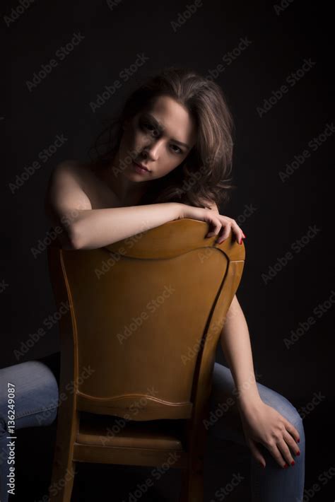 Beautiful Naked Woman On A Chair In The Dark Room Stock Photo Adobe Stock