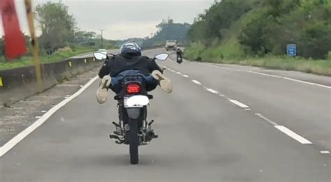 Homem é flagrado pilotando moto deitado na Antônio Heil