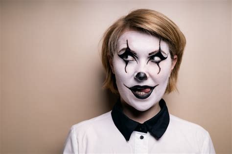 Premium Photo A Cheerful Young Girl In Halloween Makeup Looks To The Side With Her Tongue