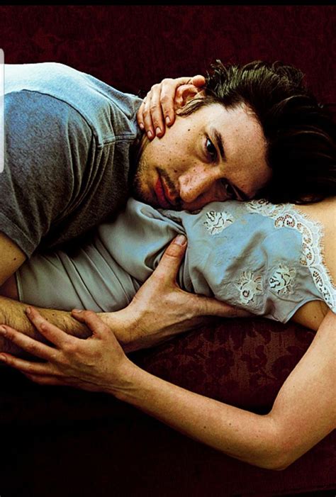 A Man And Woman Laying On Top Of A Couch Next To Each Other With Their