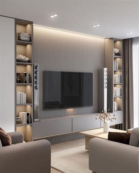 A Living Room With Two Couches And A Flat Screen Tv Mounted On The Wall