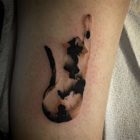 A Cat Tattoo On The Leg Of A Person S Leg With Black And White Ink