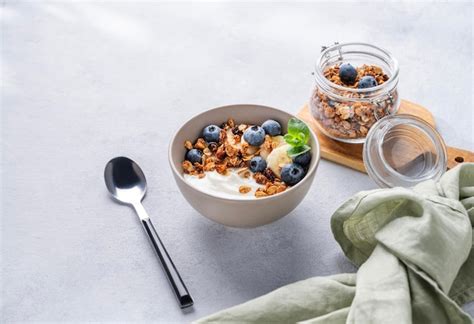 Muesli con yogur vegetariano plátano y arándanos en un bol sobre un