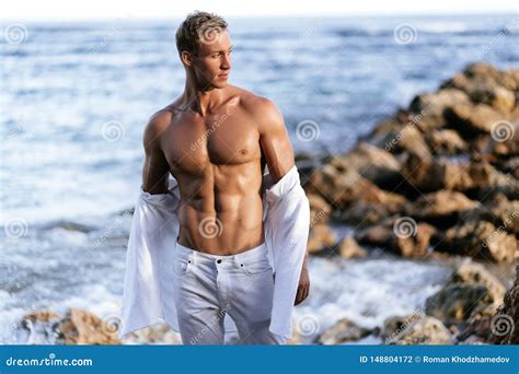 Homme Sexy Sportif Musculaire Dans Le Pantalon Blanc Avec Un Torse Nu
