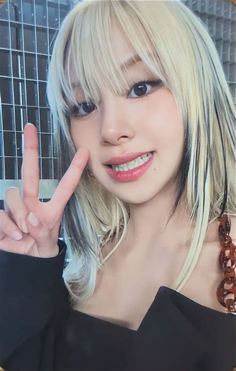 A Woman With Blonde Hair And Bangs Making The Peace Sign In Front Of Her Face