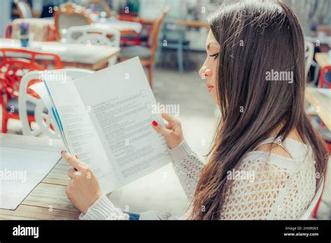 Beautiful Woman Looking At Menu And Ordering Foods In Restaurant Close