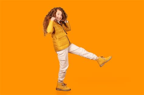 Une Petite Fille Modèle Aux Cheveux Bouclés Se Lève En S amusant Et