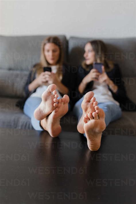 Girls In A Couch With Feet On A Table Stock Photo