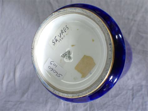 SEVRES Vase en porcelaine moucheté bleu de four et liseré or Signé