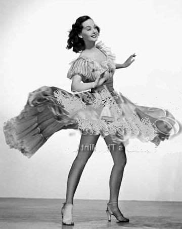 An Old Photo Of A Woman Wearing A Dress And High Heels With Her Legs