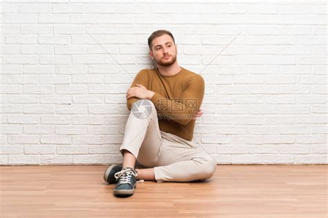 坐在地板上坐着的金发男高清图片下载 正版图片504066884 摄图网