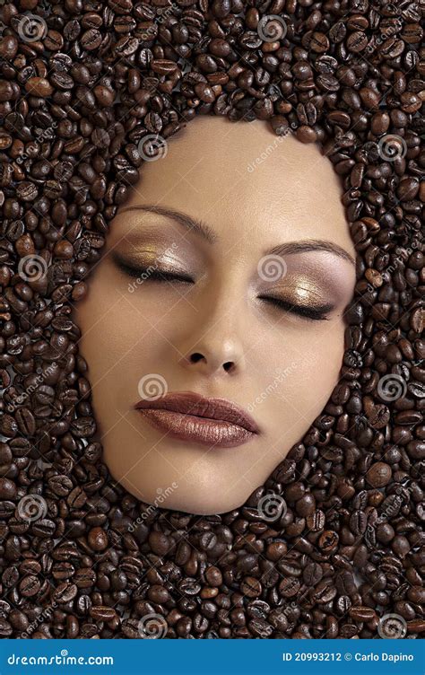 Le Visage De La Fille Immergé Dans Des Grains De Café Photo stock