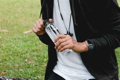 Deportista bebiendo agua de una botella después del entrenamiento
