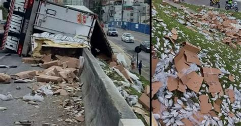 VÍDEO Caminhão carga de tainha tomba em Itapema e pessoas sobem
