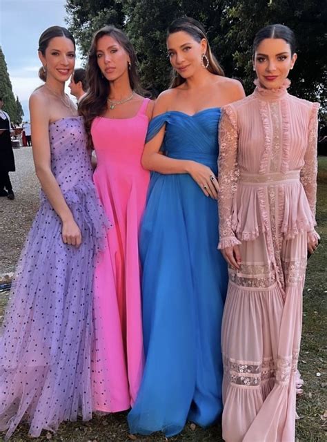Three Women In Dresses Standing Next To Each Other