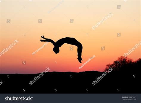 Silhouette Of Gymnast Doing A Backflip In Sunset Stock Photo 102470945
