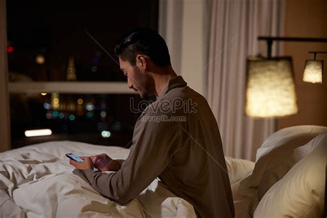 Un Hombre Acostado En La Cama Con Un Tel Fono M Vil Foto Descarga