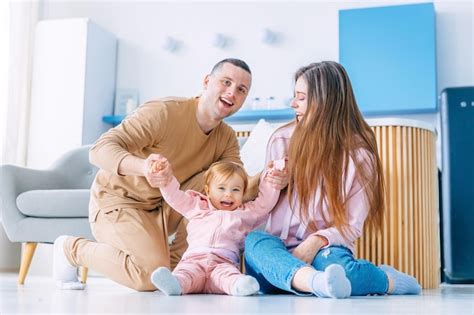 glückliche Familie sitzt mit ihrem kleinen Kind auf dem Boden und
