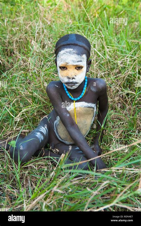 Surma Boy With Facial And Body Painting Lying On Grass Kibish Omo