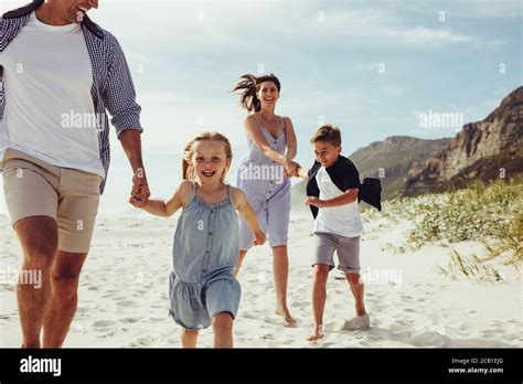 Glückliche Familie im Urlaub des gemeinsamen Laufens am Strand Kinder
