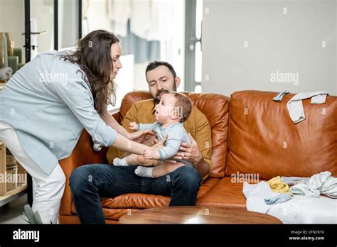La madre toma a un bebé recién nacido alimentado por papá en casa