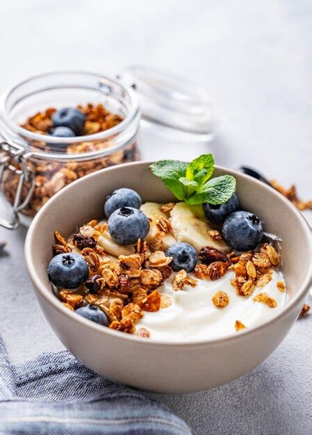 Muesli con yogur vegetariano plátano y arándanos en un bol sobre un