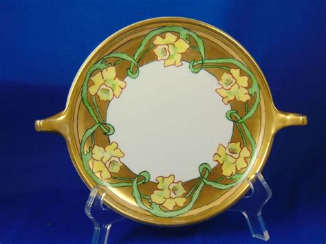 A Gold Plate With Flowers Painted On It