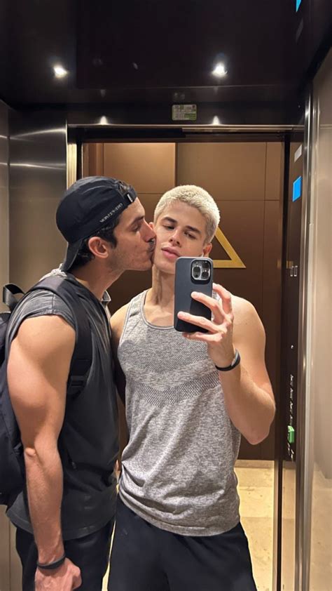 A Man And Woman Taking A Selfie In An Elevator With Their Cell Phones