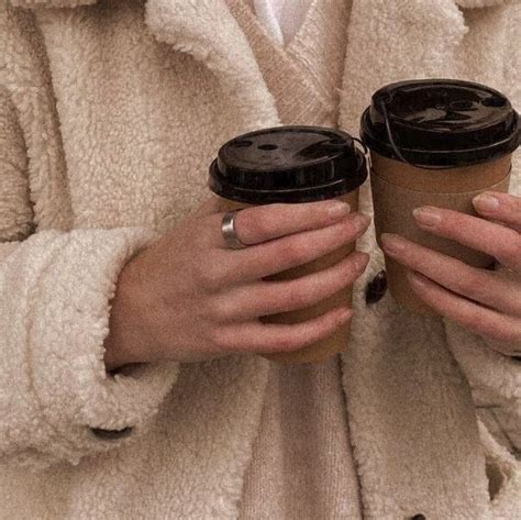 A Woman Holding Two Coffee Cups In Her Hands