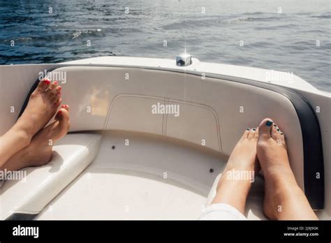 Two Sets Of Lady Feet Resting On Bow Of Boat Stock Photo Alamy