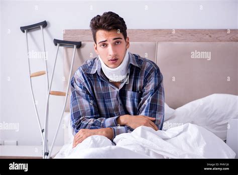 Injured Man In Bed At Home With Crutches Stock Photo Alamy