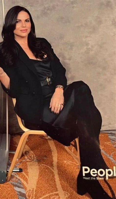A Woman Sitting In A Chair With Her Legs Crossed