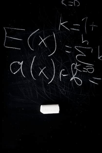 Parte de fórmulas matemáticas escritas con tiza blanca en el fondo de