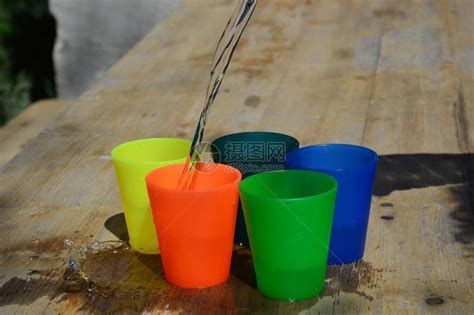 木桌上五颜六色的塑料杯装满水高清图片下载 正版图片506003158 摄图网