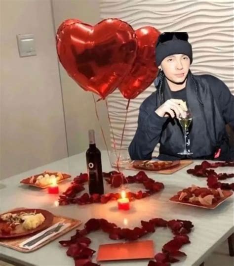 A Person Sitting At A Table With Heart Shaped Balloons
