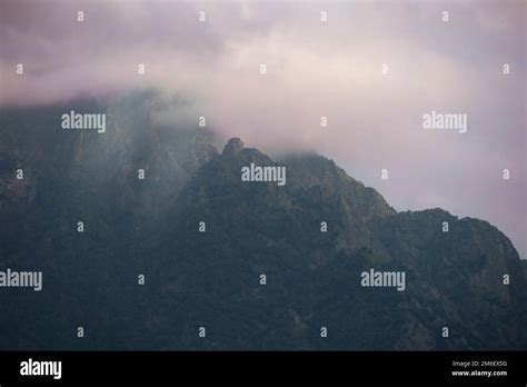 Paisaje surrealista atmosférico oscuro con un pico de montaña rocosa