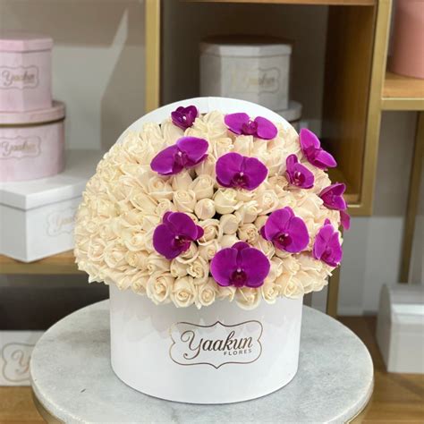 Caja Circular Blanca Con 150 Rosas Blancas Y Toques De Orquidea