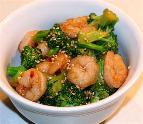 A White Bowl Filled With Broccoli And Shrimp