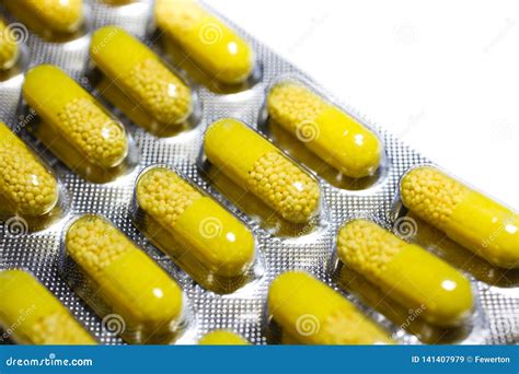 Yellow Capsules With Yellow Granules Medicine In Gray Tablet Pill