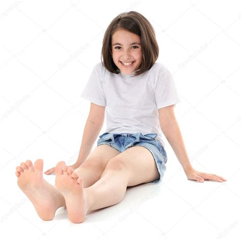 Preteen Girl Sitting On Beach With Barefeet Hugging Knees Stock