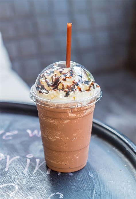 A Chocolate Drink With Whipped Cream And Toppings On The Top Is Sitting