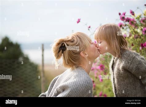 Mother Kissing Son In Organic Garden Stock Photo Alamy