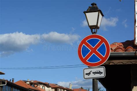 Traffic Sign No Stopping On Streetlight Against Blue Sky Stock Photo