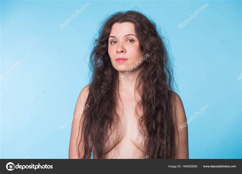 Portrait Of Sensual Nude Woman With Curly Hair On Blue Background