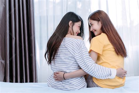 Casal de lésbicas asiáticas do mesmo sexo se abraça no quarto download