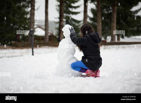 Girl Making A Snowman Stock Photo Alamy