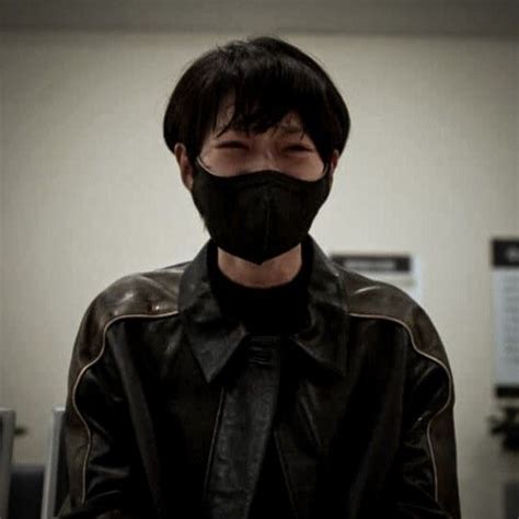 A Man Wearing A Black Mask And Leather Jacket In An Office Setting With