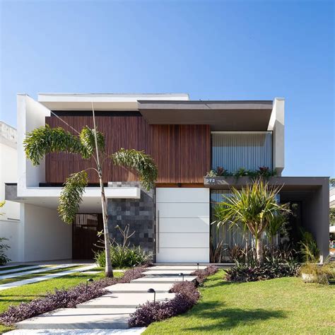 Fachada de casa contemporânea volumetria painel ripado de madeira
