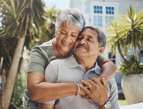 Senior Couple And Old Man And Woman Hug With Love Care And Support Outside Their Home Or House