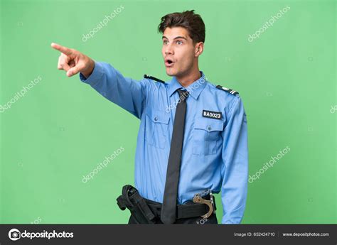 Joven Policía Sobre Fondo Aislado Apuntando fotografía de stock